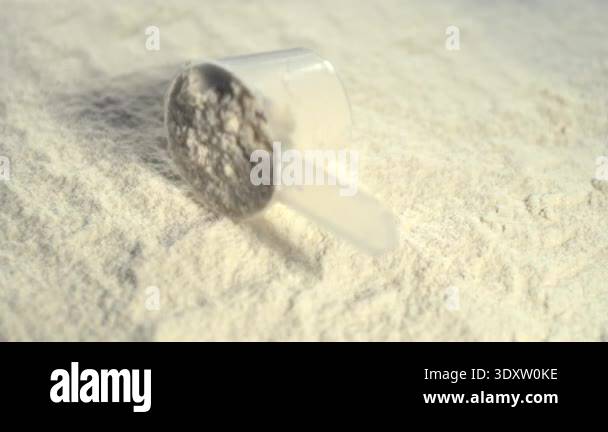 super slow motion white powder scoop spilling creatine, closeup studio ...