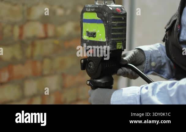 Professional laser level tool on tripod checking vertical alignment and ...