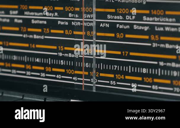 Close-up of a vintage radio tuner dial with an orange needle scanning ...