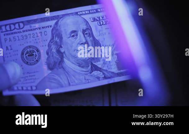 Macro view of a hand holding a one hundred US dollar bill as an ...