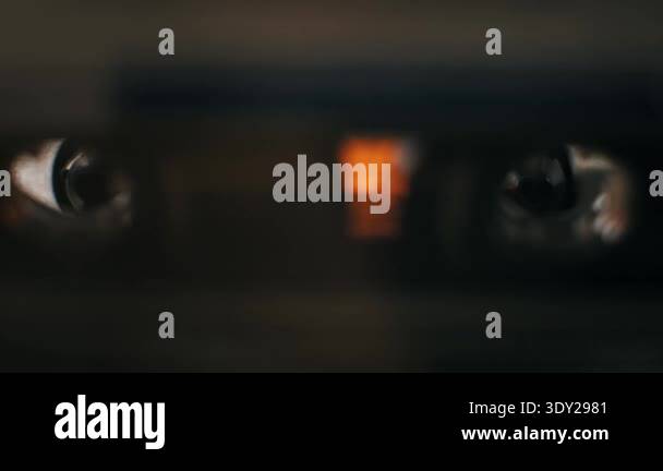 Macro close-up of a vintage audio cassette playing in a tape deck ...