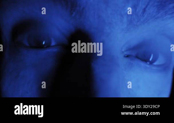 Male face stares into camera with wide terrified eyes under ...
