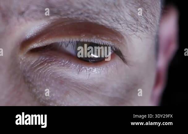 An extreme close-up shot of a human male eye darting nervously and ...