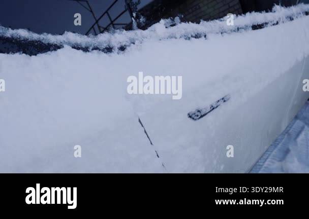 A white car door handle and window trim sit buried under a heavy layer ...