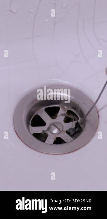 A hand pulls a disgusting clump of hair and grime from a clogged ...