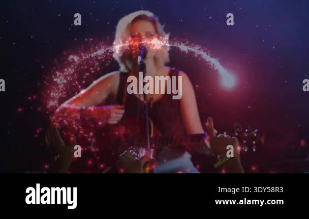 Teenage female singer playing guitar at concert initiating red sparkly ...