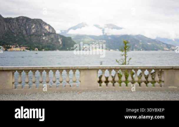 Lakeside balustrade with distant mountains and lake in soft defocused ...