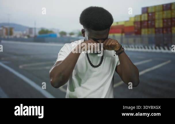 Man rubbing his eyes with clenched fists on a street by shipping ...
