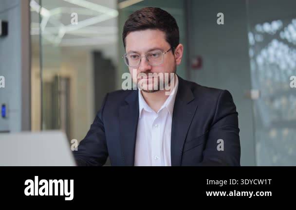 Professional person works diligently on laptop in modern office. Looks ...