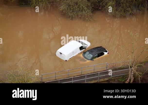 Flood disaster submerging road and vehicles in muddy river water. Drone ...