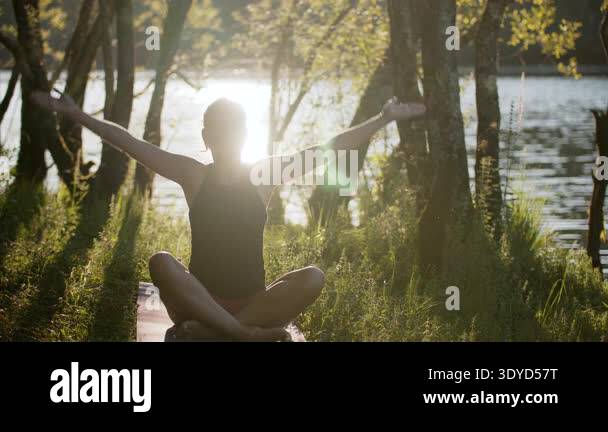 Woman is practicing yoga in nature. Seated gentle easy pose for relief ...