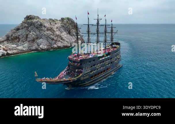 Pirate cruise ship with tourists onboard departs to sea from coast ...