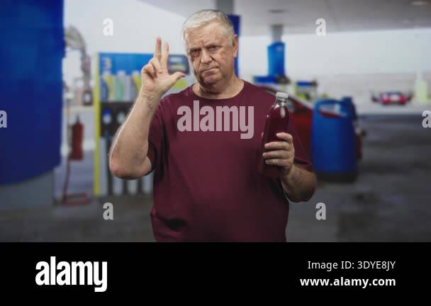 Man holding a bottle of pomegranate juice, hand raised and speaking in ...