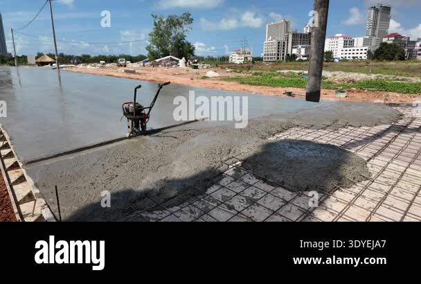 Ground level road construction, concrete on rebar mesh, screed machine ...