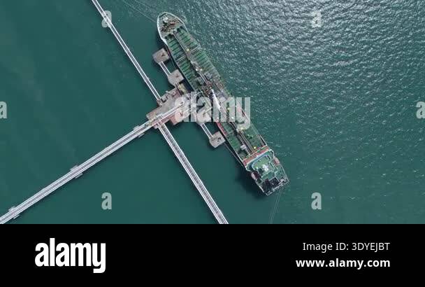Top down turning aerial tanker docked at offshore pipeline terminal ...