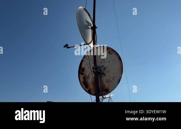 Closeup satellite dishes under bright sky vertical pole supporting two ...