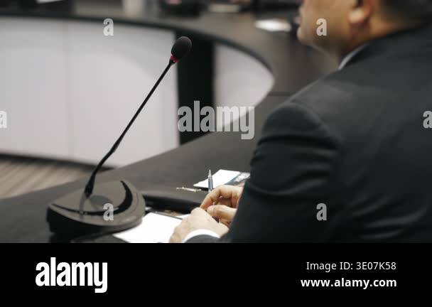 Business professional speaking into conference microphone during ...