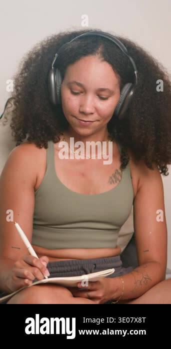 A focused young Black woman with beautiful natural curly hair is seen ...
