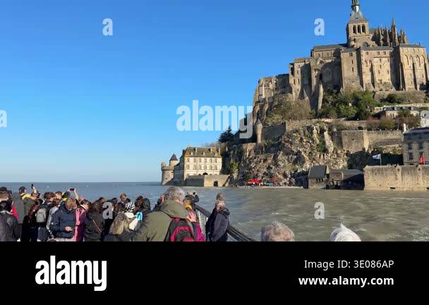 Mont Saint Michel, France - 1 April 2025. Visitors stand by as seawater ...