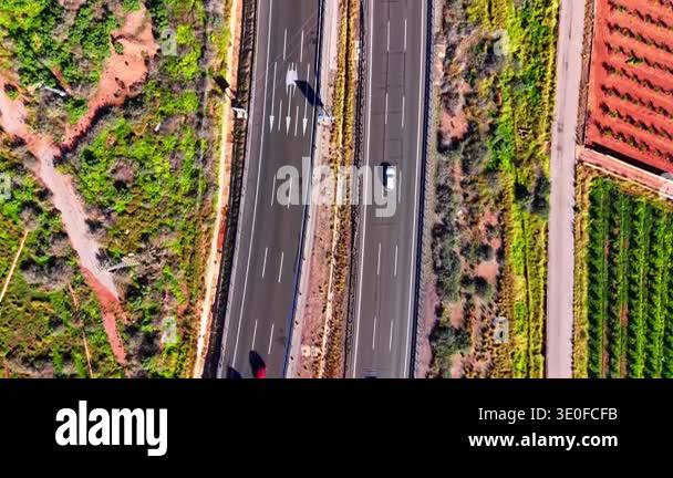 Asphalt motorway with road markings and a single car driving between ...