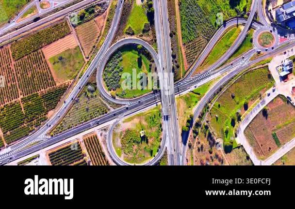 Aerial shot of a multi-level road junction with loop ramps, green ...