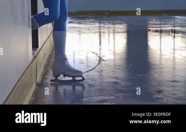 A close up of a figure skater legs begins training on a shiny indoor ...