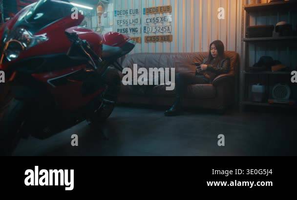 Woman Reclining in Garage With Phone and Sport Motorcycle. Female in ...