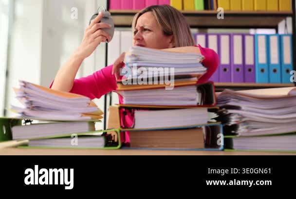 Overloaded employee with too much work and documents holds alarm ...
