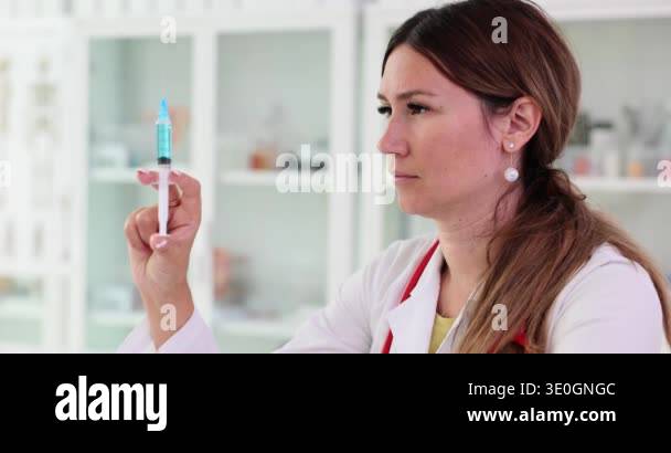 Female doctor adds liquid to injection before administering to patient ...