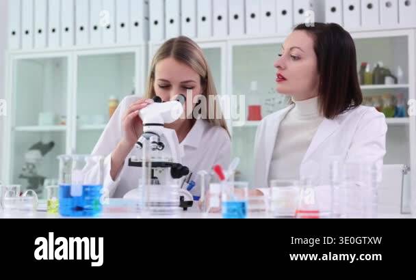 Women scientists observe specimen and react with surprise. Qualified ...