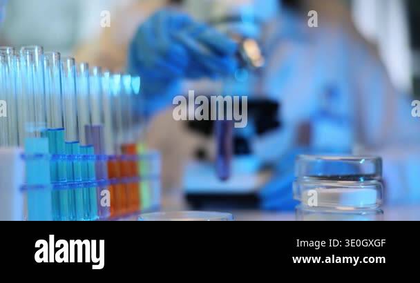 Researcher moves test tube on table with laboratory equipment. Woman ...