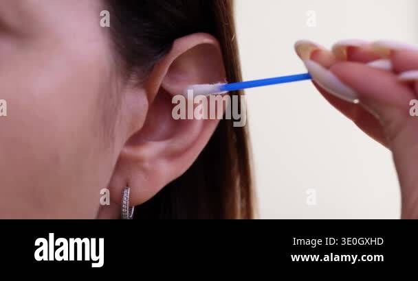Young woman conducts ear cleaning with ear stick in morning. Lady ...