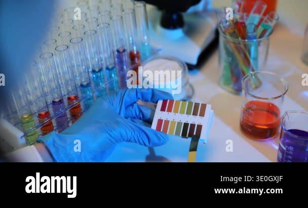 Laboratory technician uses color palette comparing patterns on paper ...