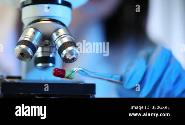 Microscopic analysis of a medical red and yellow capsule in a ...