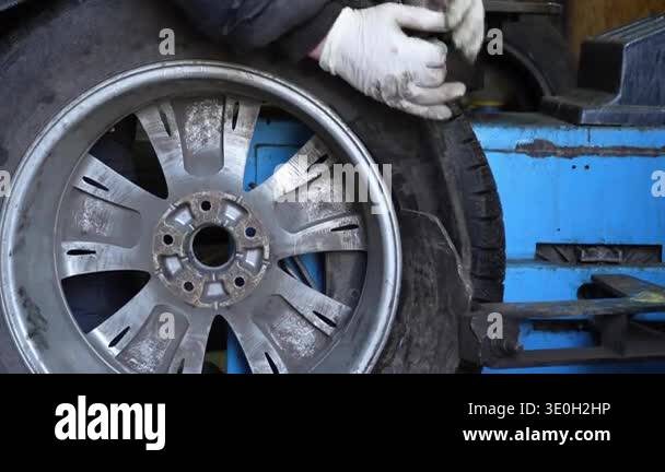 Auto mechanic removing a car tire from wheel rim using tire changing ...