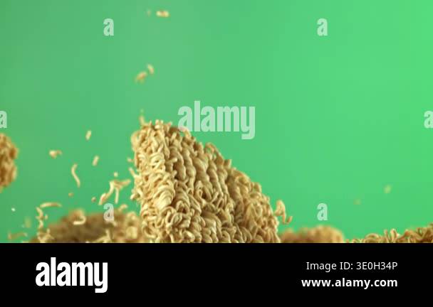 Instant noodles fly up and fall down on a green background. Filmed on a ...