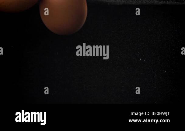 Eggs falling under water on a black background. Filmed on a high-speed ...
