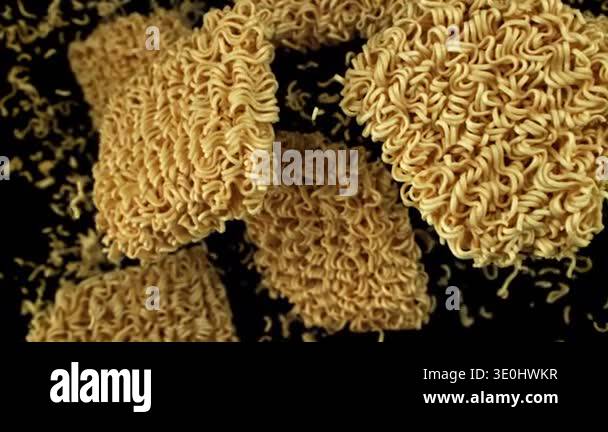 Instant noodles fly and fall on a black background. Filmed on a high ...