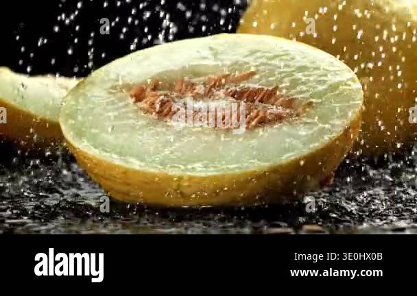 Drops of water fall on a fresh melon. Filmed on a high-speed camera at ...
