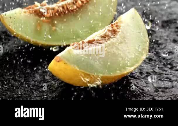 Drops of water fall on a fresh melon. Filmed on a high-speed camera at ...