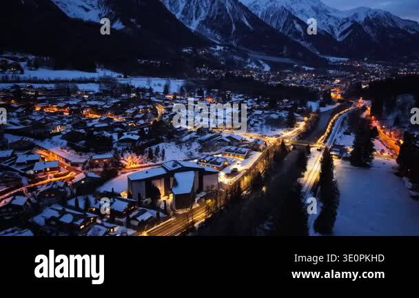 Aerial view of Chamonix valley at twilight. Bright lights illuminate ...