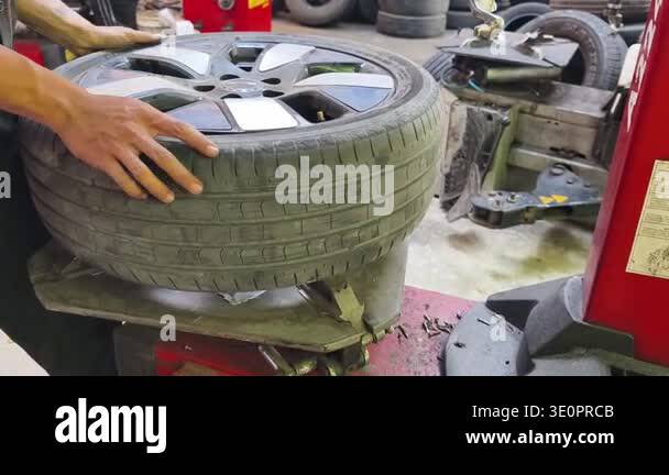 Mechanic changing car tire on red tire changer Stock Video Footage - Alamy