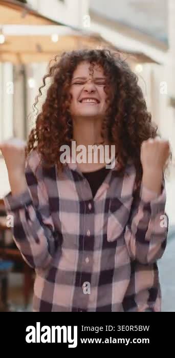 Portrait of pretty young woman shouting, celebrating success, winning ...