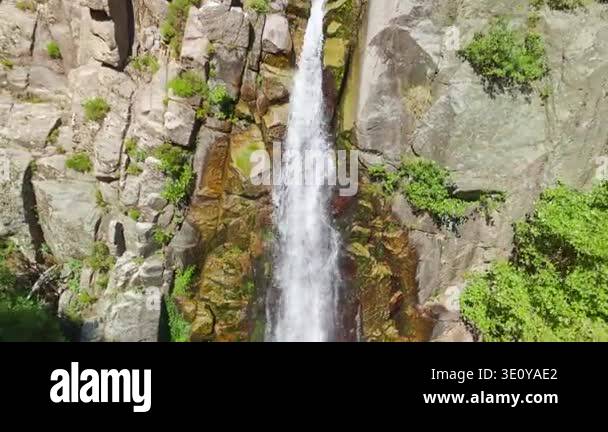 Aerial view of a stunning waterfall cascading into crystal clear ...