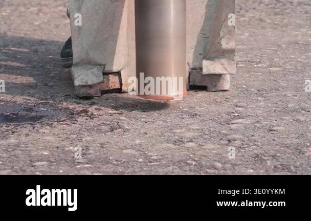 Close-up of an industrial drill bit boring a large deep hole in the ...