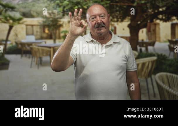 Man makes ok sign with raised right hand, visible mustache and white ...
