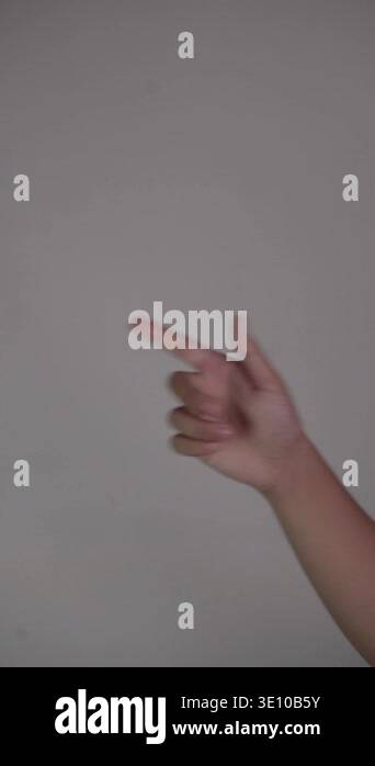 Close up of a brown hand making a shooting gesture, plain white ...