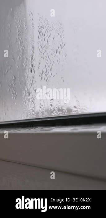 Water droplets from condensation evaporate from a window pane in a time ...