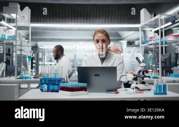 Tired female scientist feeling headache while working on laptop in lab ...