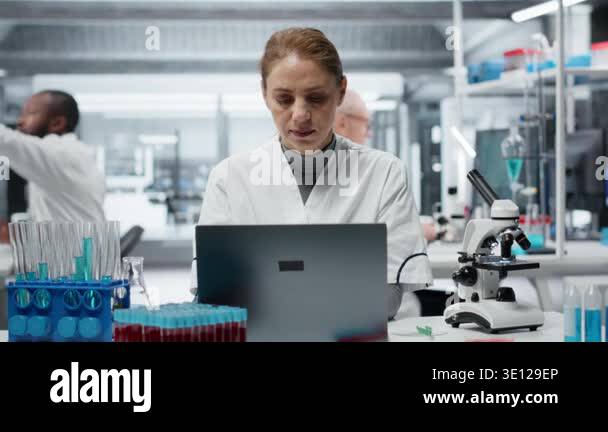 Sick lab expert rubbing head temples, feeling ache while working on ...